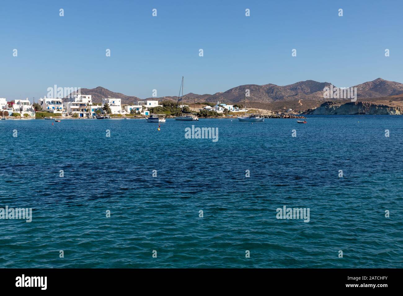 Clear water and buildings at beach in Pollonia village, Milos, Greece ...