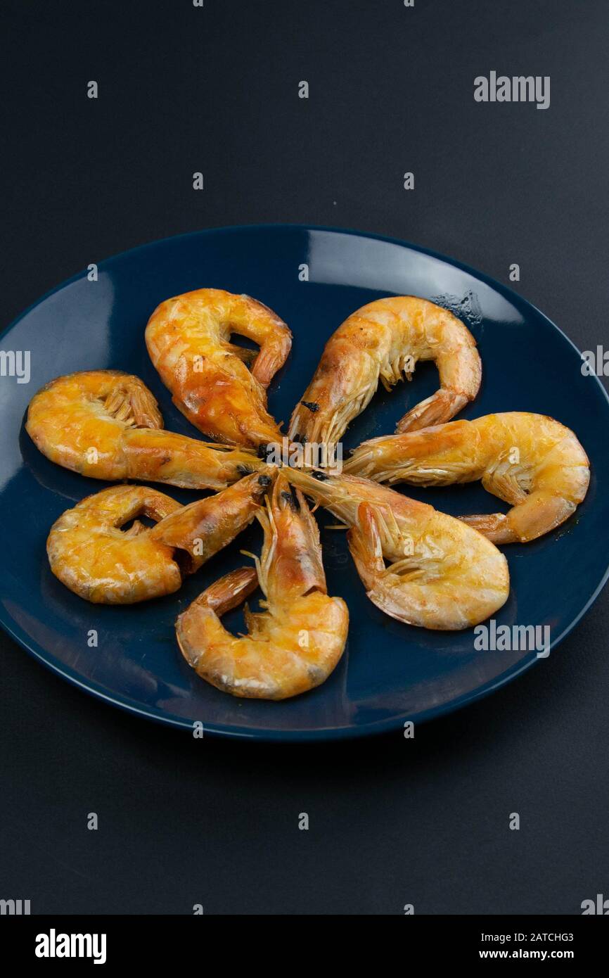 Closeup of cooked shrimps served on blue plate Stock Photo - Alamy