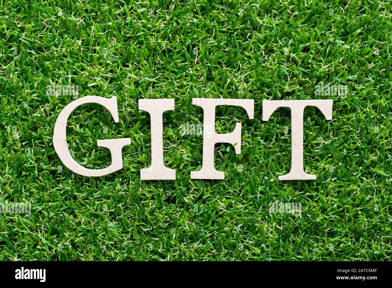 Wood alphabet in word gift on artificial green grass background Stock ...