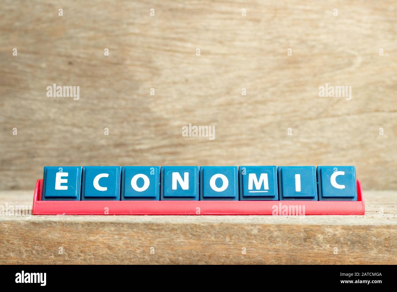 Tile letter on red rack in word economic on wood background Stock Photo ...