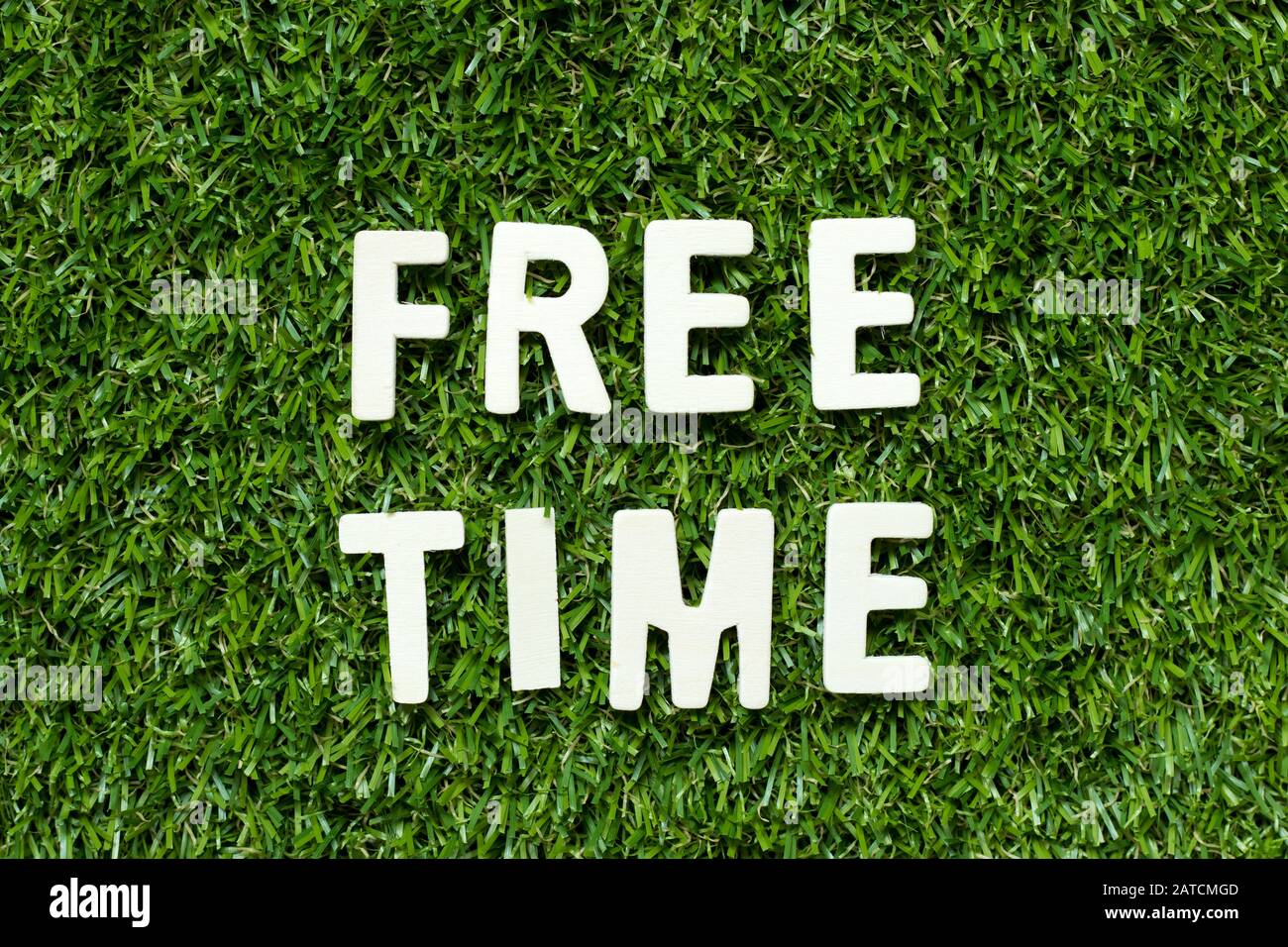 Alphabet letter in word free time on artificial green grass background ...