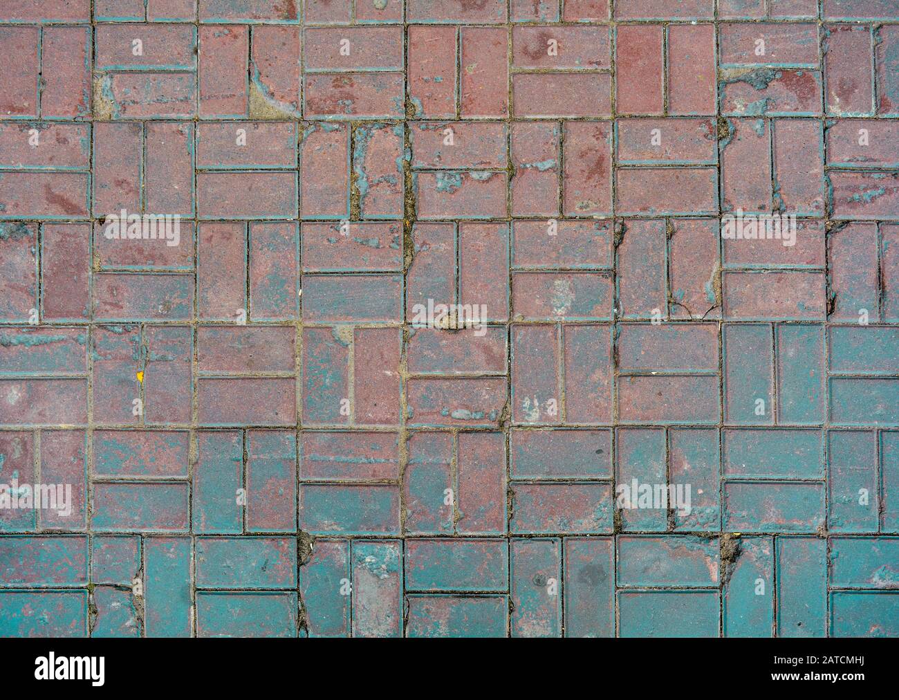 Grunge cracked red street tiles with blue paint. City street pavement ...