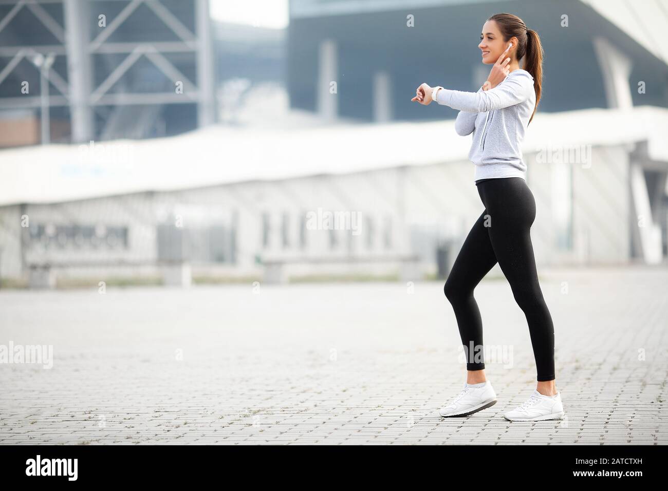 Fitness woman doing workout standing in a stadium background Stock ...