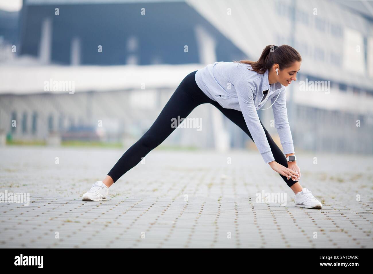 Fitness woman doing workout standing in a stadium background Stock ...