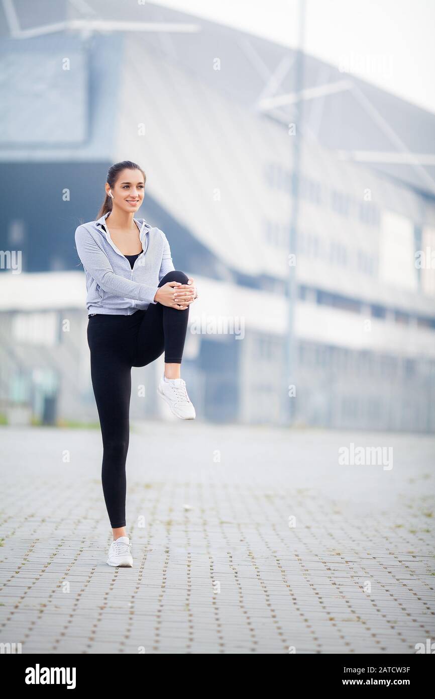 Fitness woman doing workout standing in a stadium background Stock ...