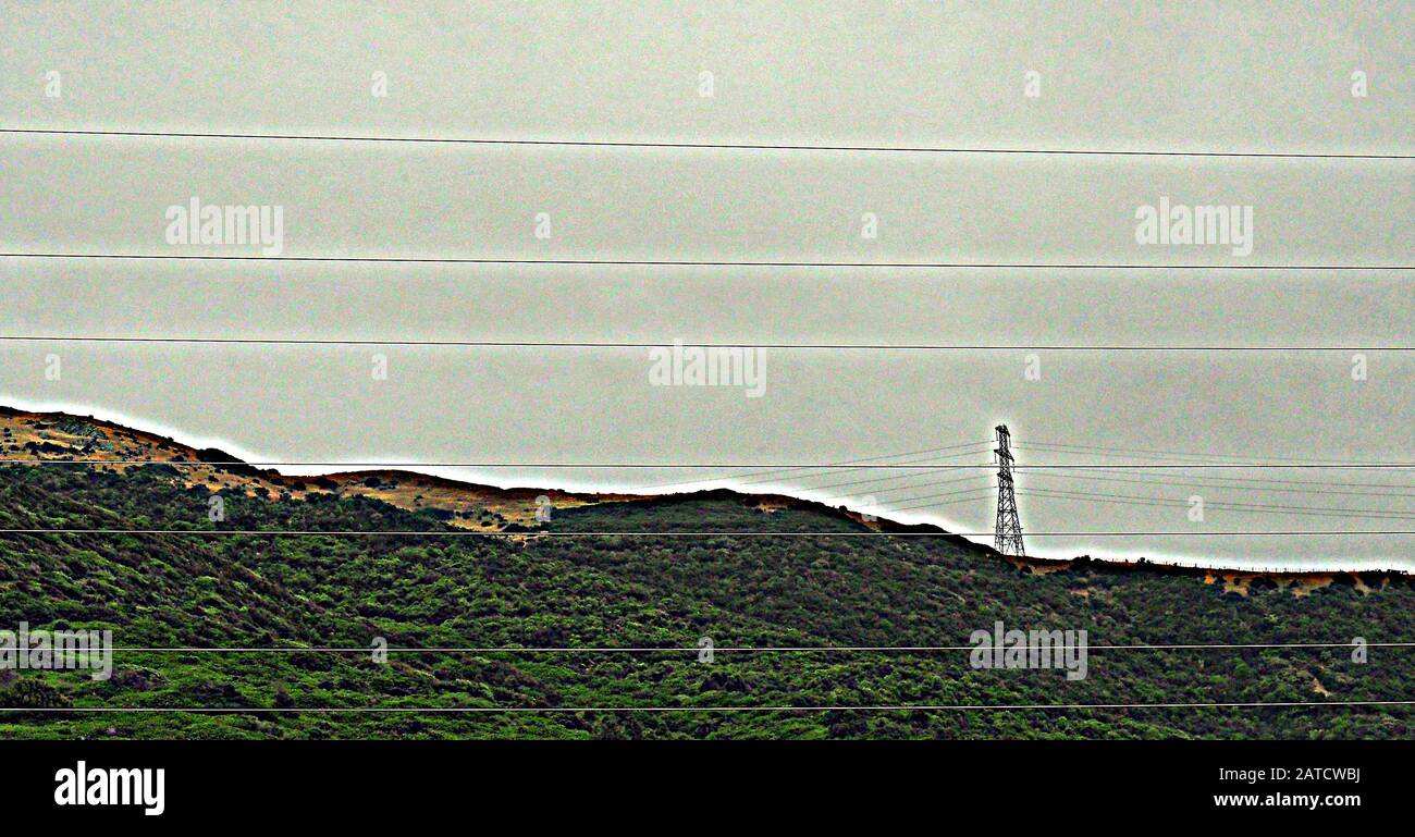 Power lines with an HDR emphasis cross a wide valley; a pylon transmits ...
