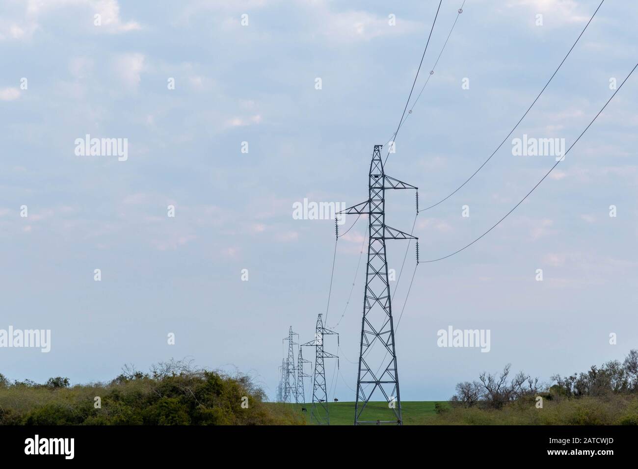 An electrical power grid supported by a group of power towers arranged ...