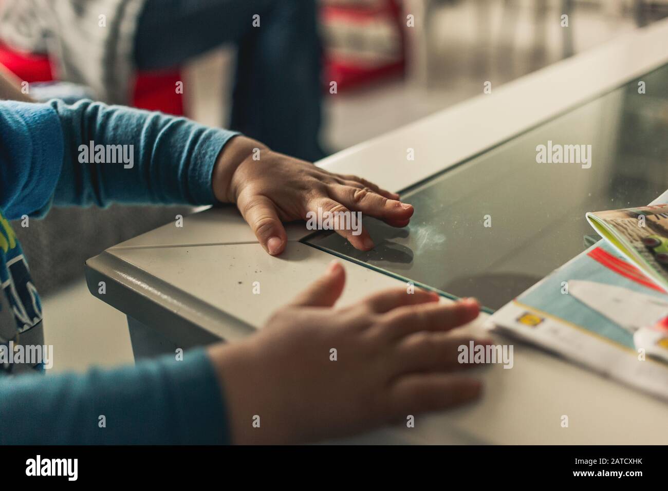 Cute hands of a child on the corner of the white table Stock Photo - Alamy