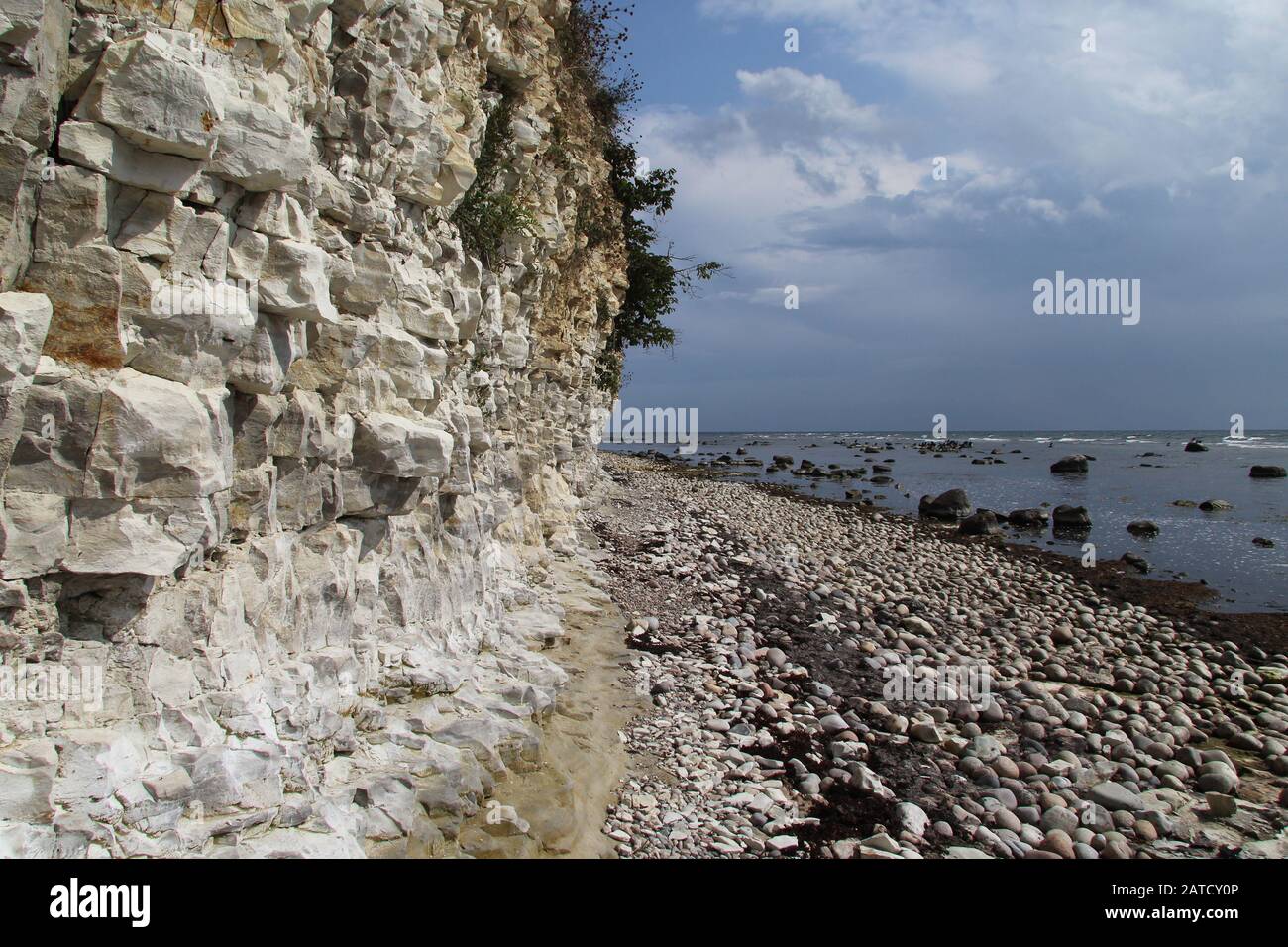 Side view of a white limestone cliff coast with a view of the stony ...