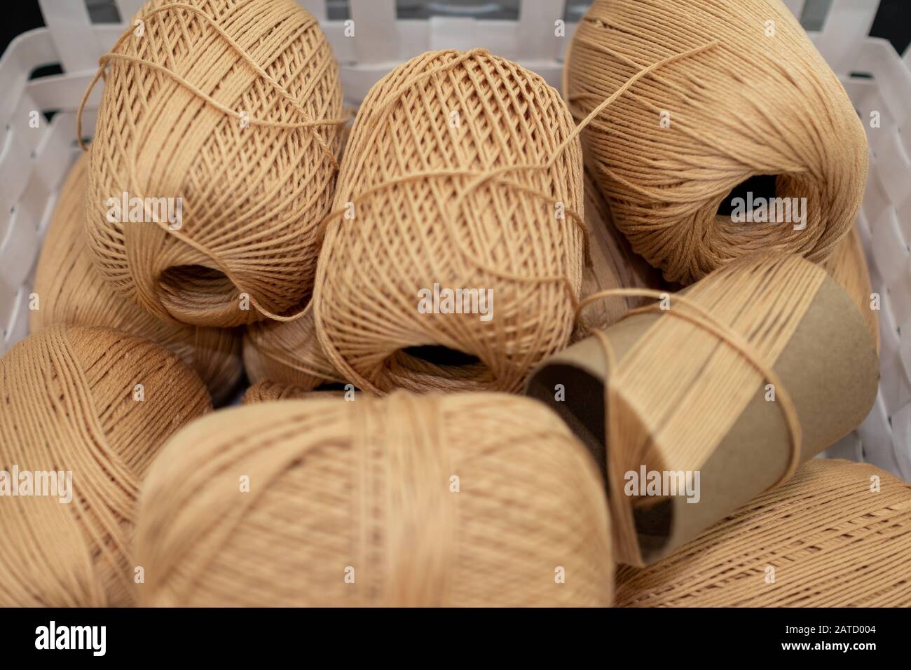 Set of brown rolled yarns in a white basket Stock Photo - Alamy