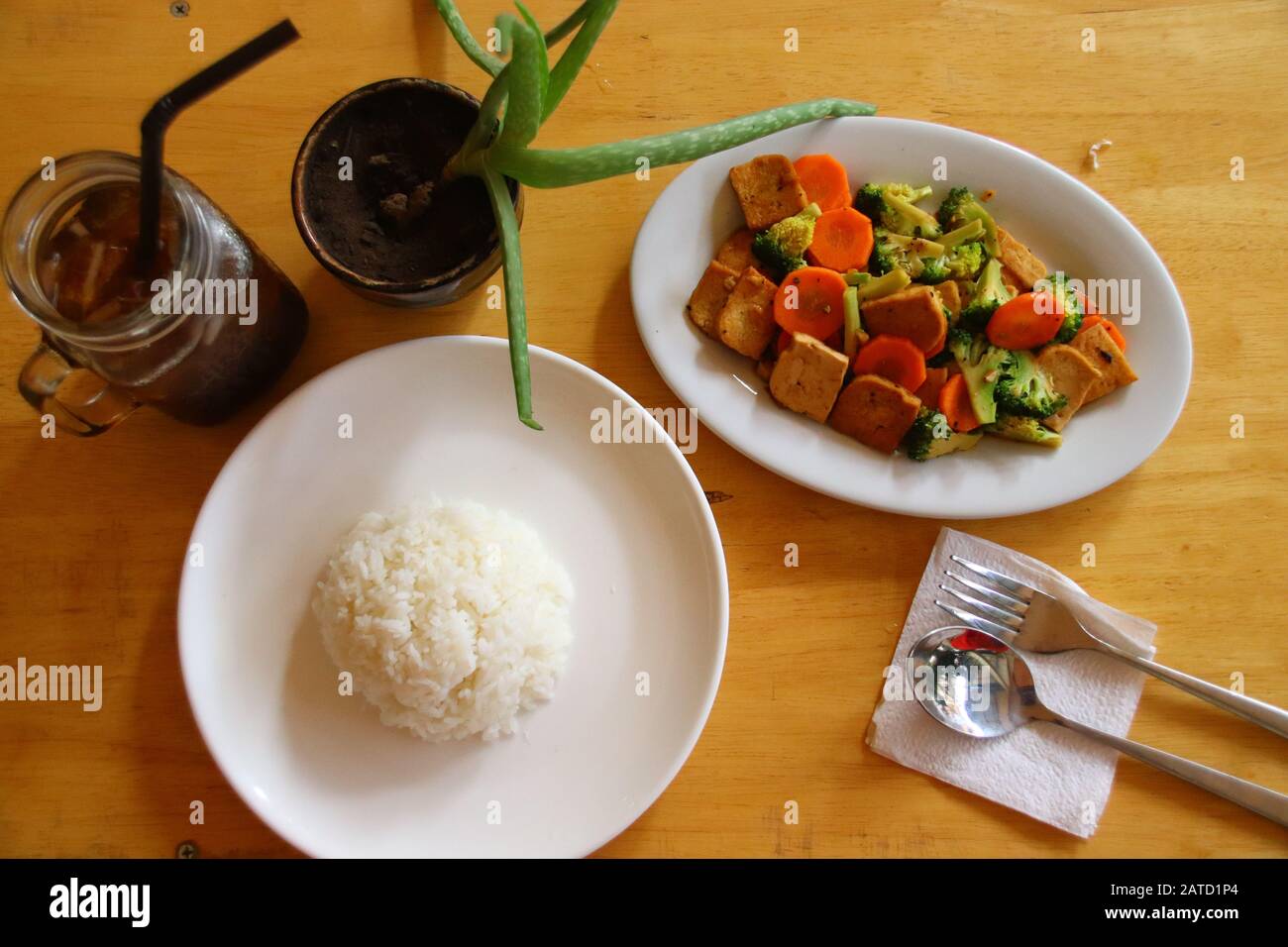 Overhead view of stir-fried tofu and vegetables, steamed white rice and ...