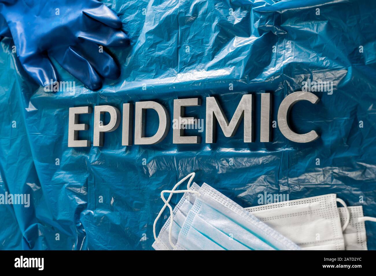 the word epidemic laid by metal letters in crumpled blue plastic ...