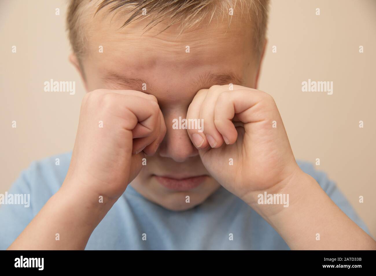 boy holding his hands up to his eyes while crying Stock Photo - Alamy