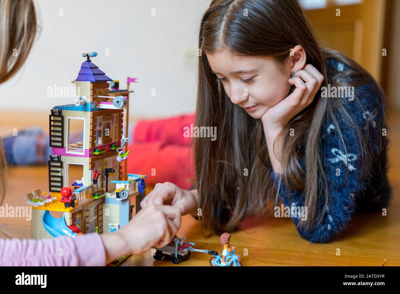 Little girl plays with a children's constructor at home. Little girl ...