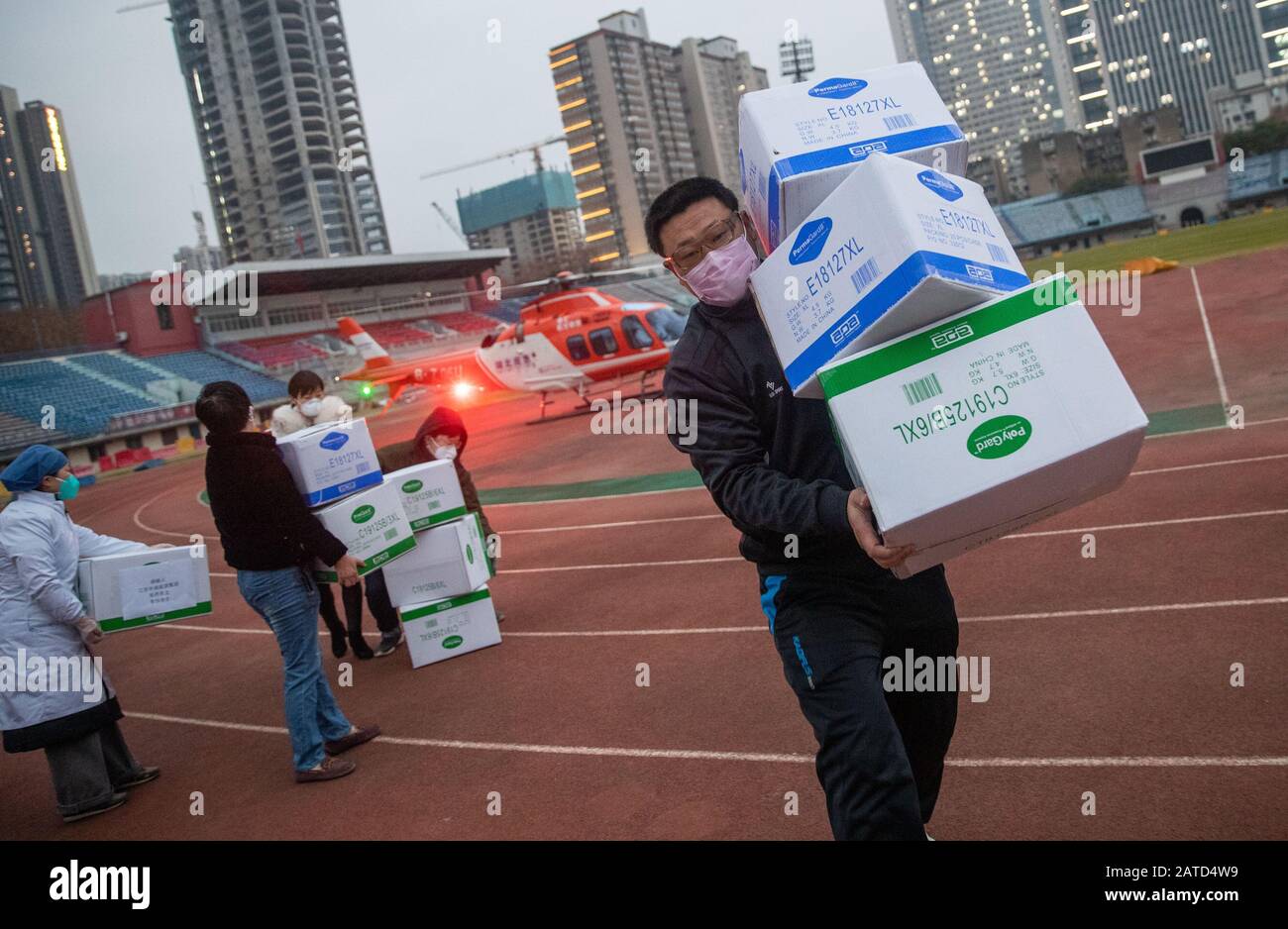 Chinese medical workers carry cartons of medical materials delivered by ...