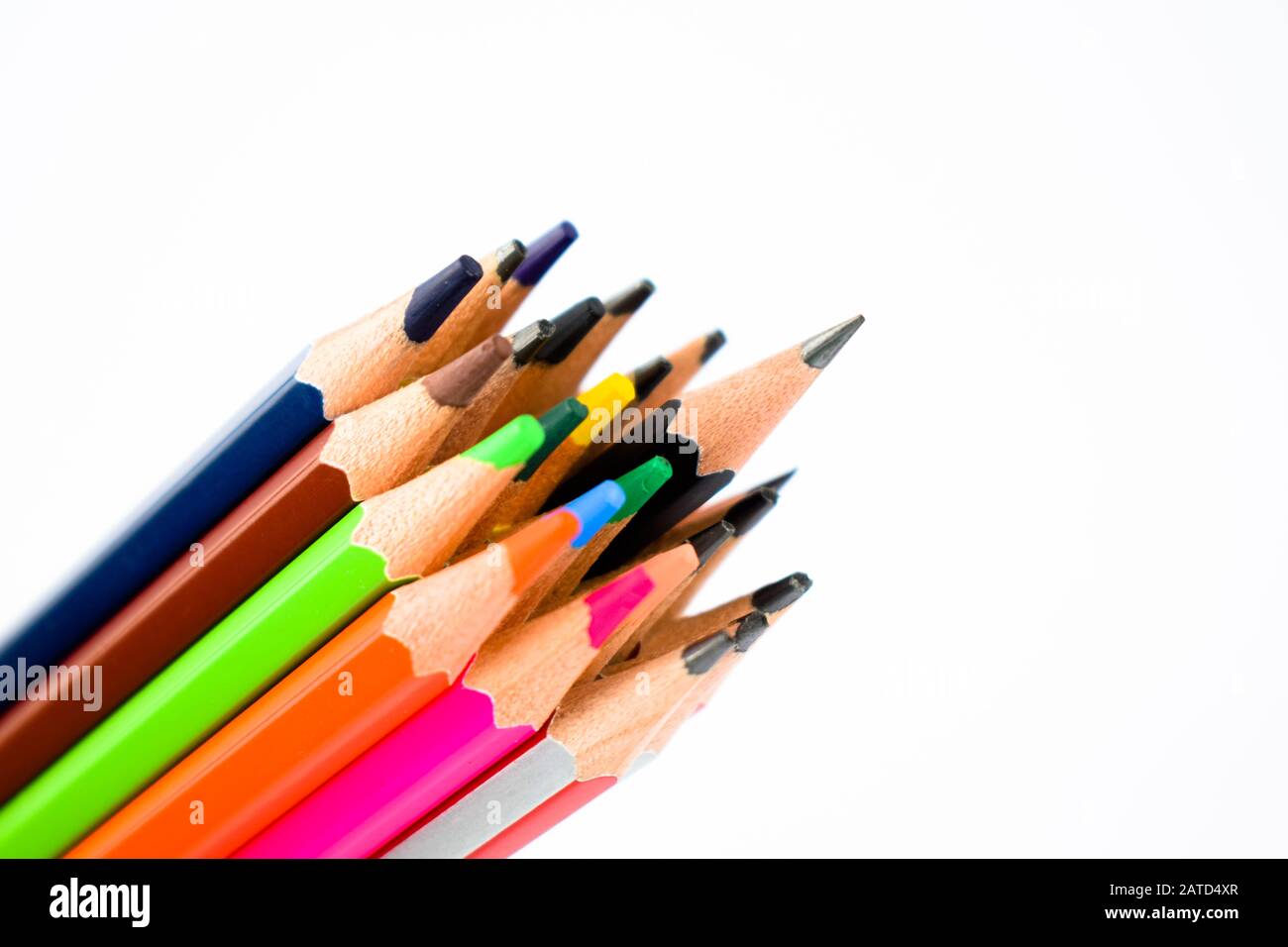 Assortment of different colored pencil crayons pointing up on a white ...