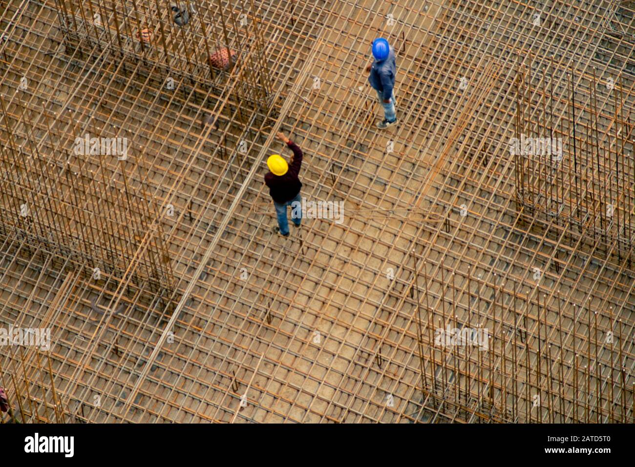 Construction workers in India standing on a rebar reinforcing bar ...