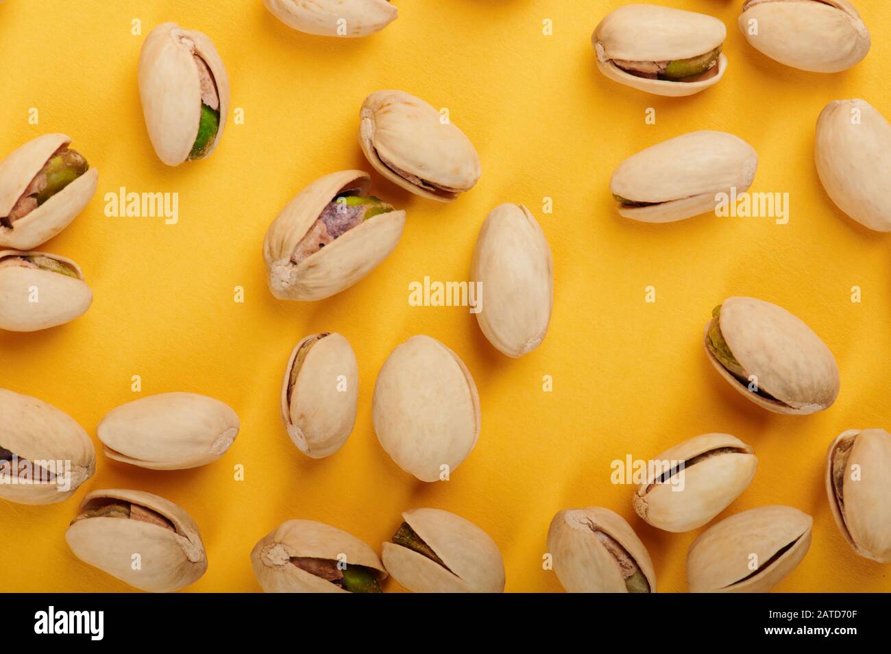 Dry pistachio nuts in shell on yellow background Stock Photo - Alamy