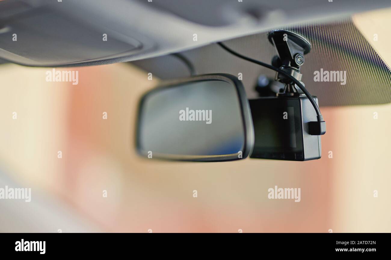 Black dashcam video recorder behind mirror close up view Stock Photo ...