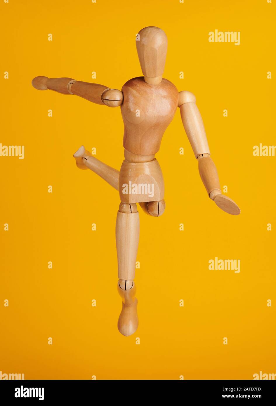 Wood figure in soccer pose isolated on yellow background Stock Photo ...