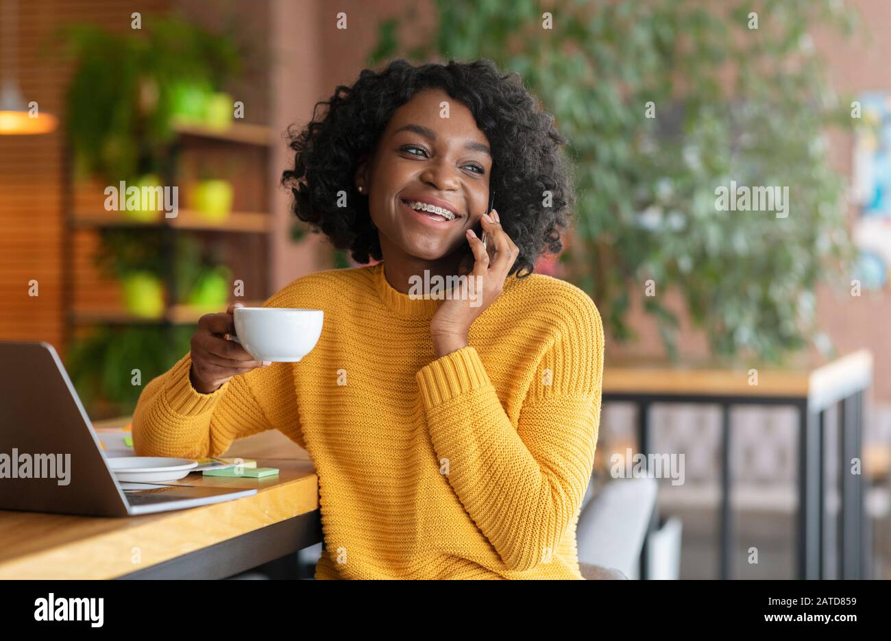 Positive afro girl having conversation with clients on phone Stock ...