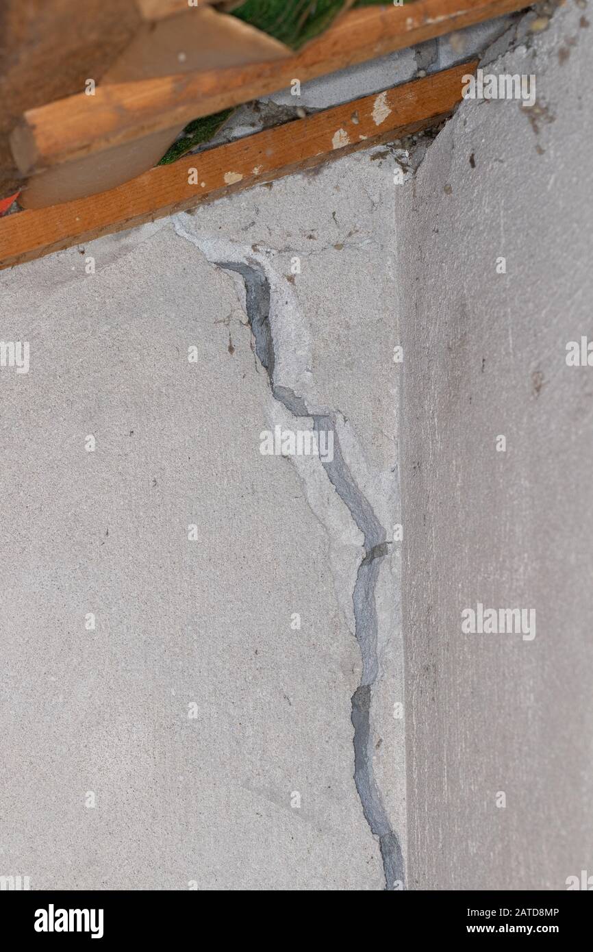 Plastered interior brick wall with large cracks showing construction ...