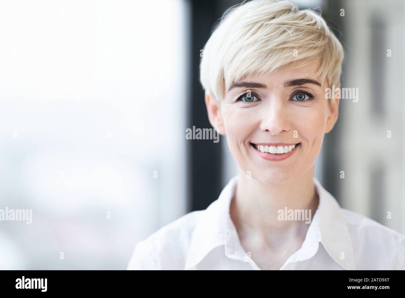 Mature Woman Smiling Standing Against Window Indoors, Portrait Stock ...
