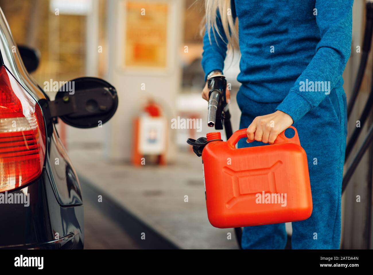 Female person filling canister on gas station Stock Photo - Alamy