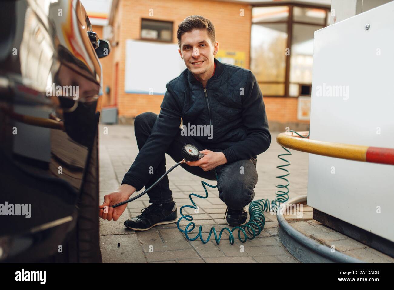Male person checks the tire pressure, tyre service Stock Photo - Alamy