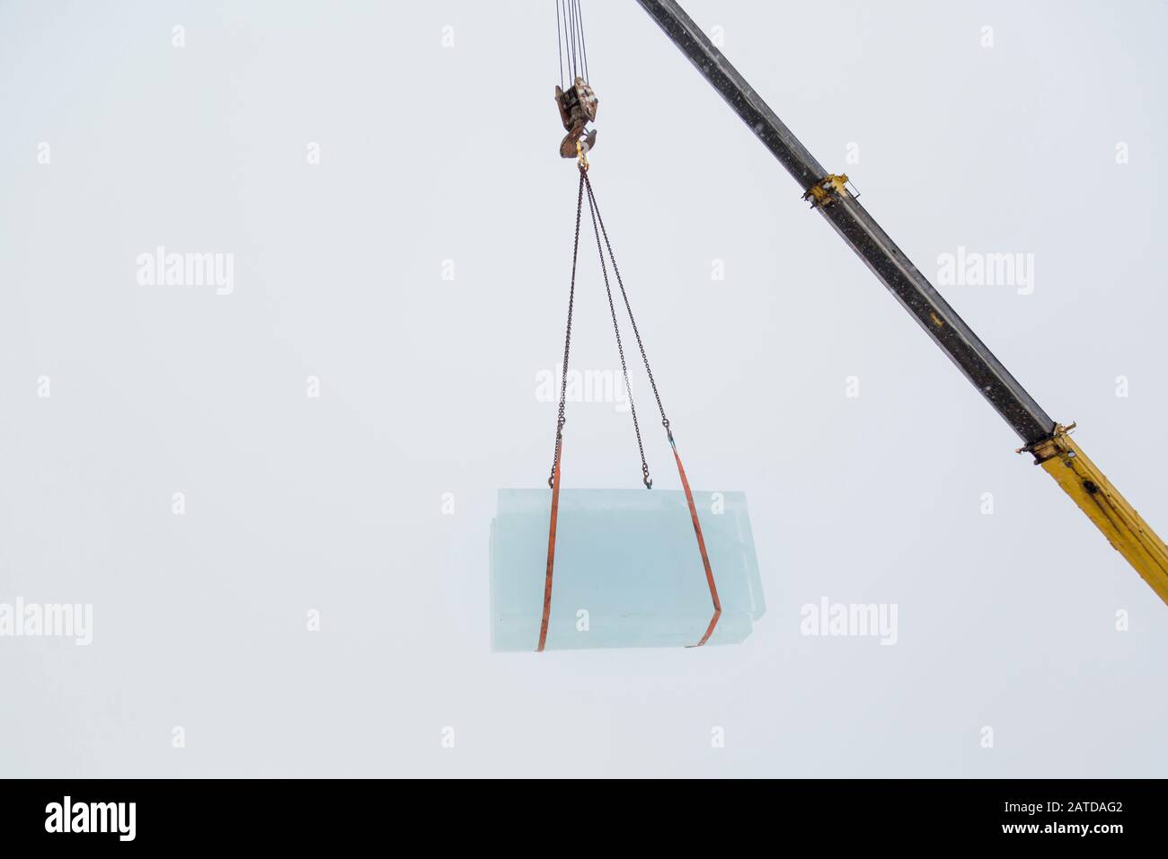 Truck crane lifts transparent ice slabs by the river Stock Photo - Alamy