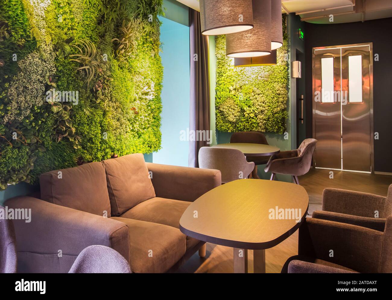 Empty cafe with artificial plant decoration on the wall Stock Photo - Alamy