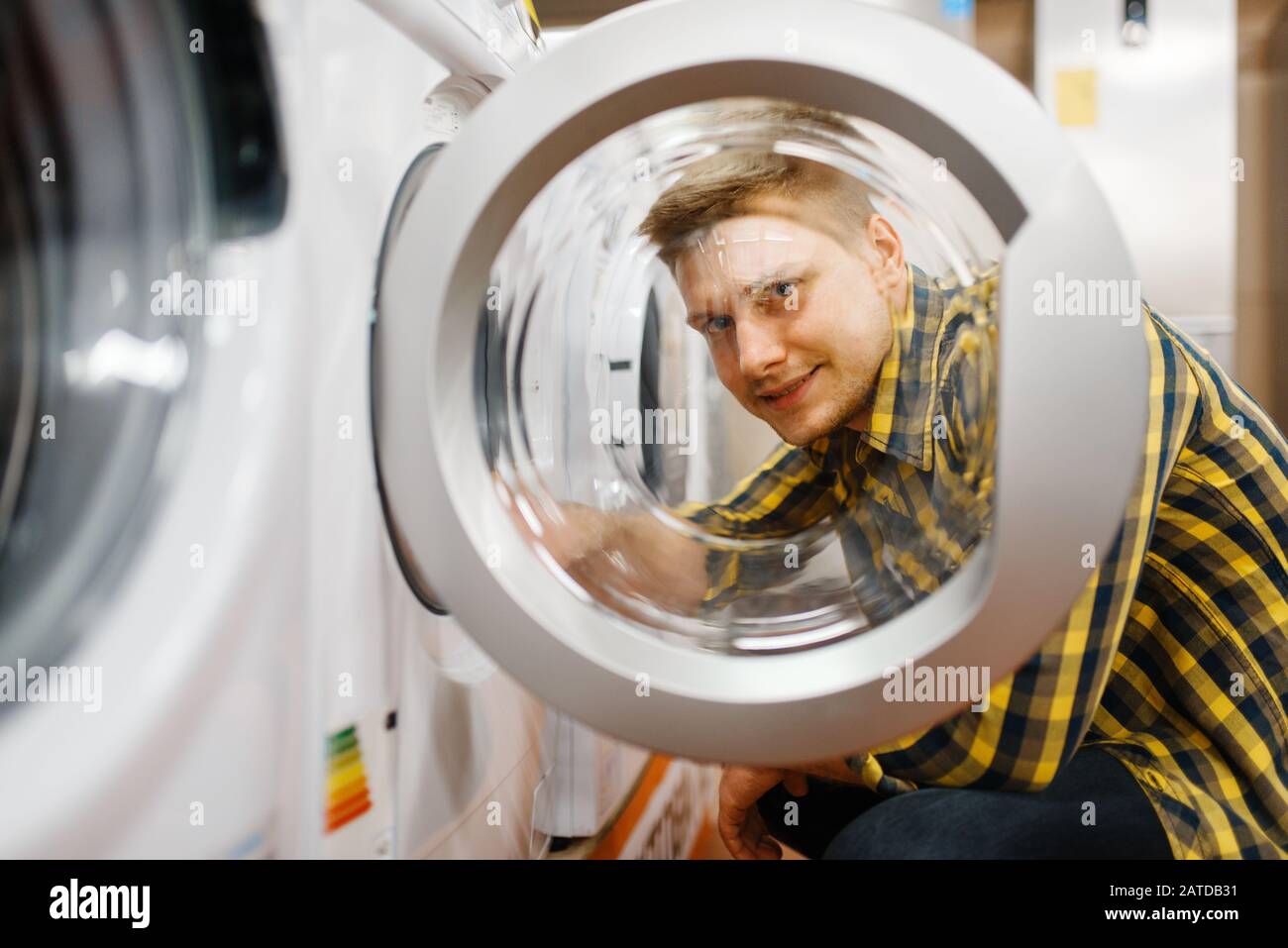 Man choosing washing machine in electronics store Stock Photo - Alamy