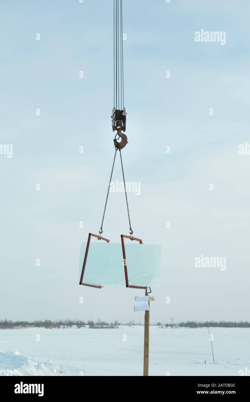 Truck crane lifts transparent ice slabs by the river Stock Photo - Alamy