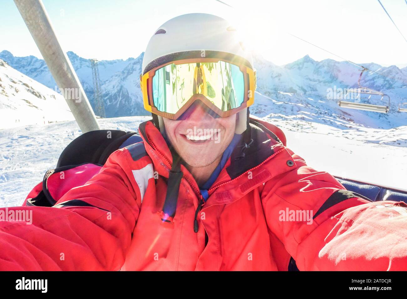 Happy skier taking selfie photo with smart cell phone camera sitting on ...