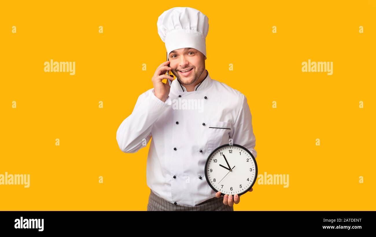 Professional Cook Talking On Phone Holding Clock Standing In Studio ...