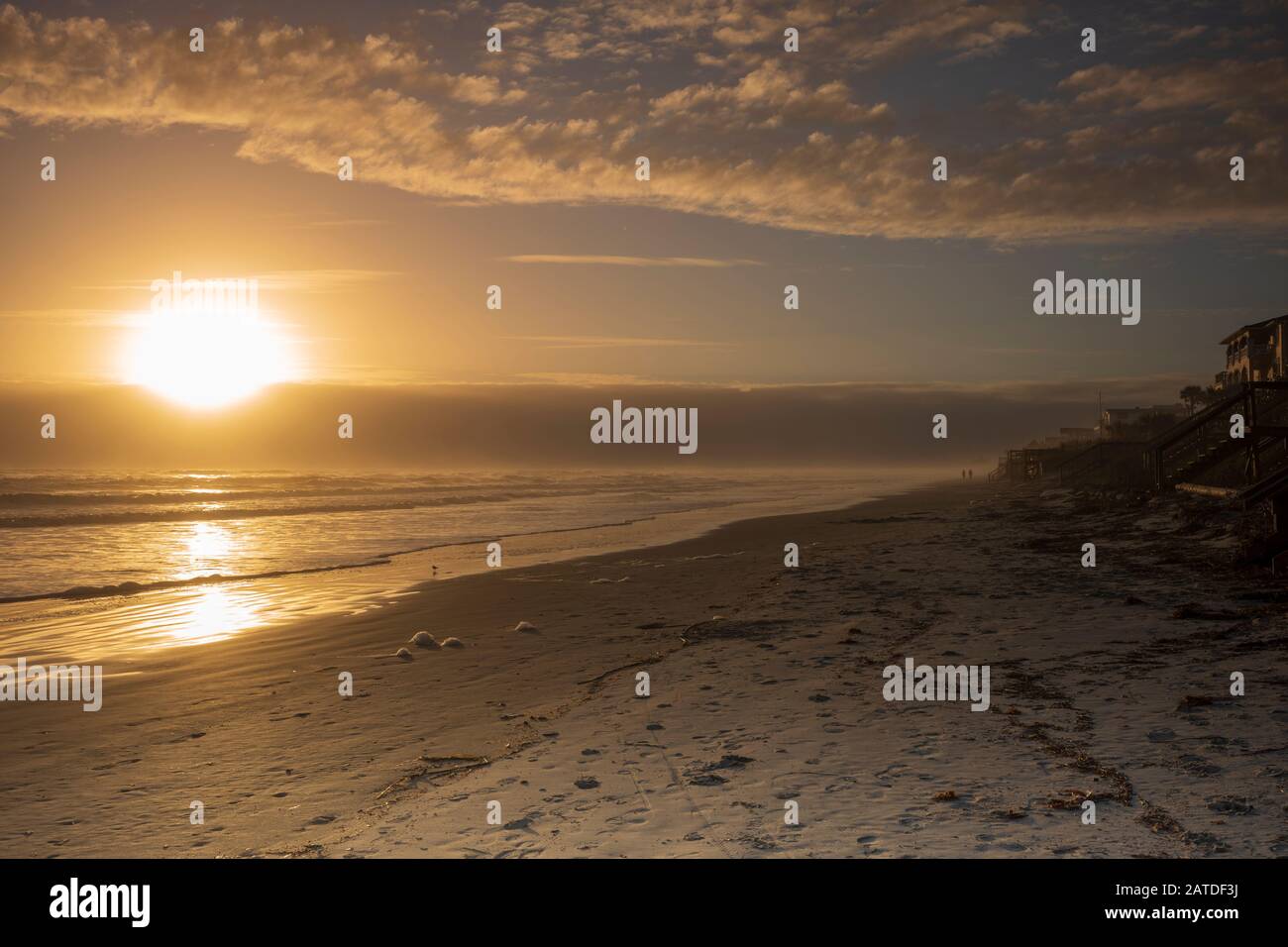 A silhouetted couple walks down the beach in Port Orange, Florida ...