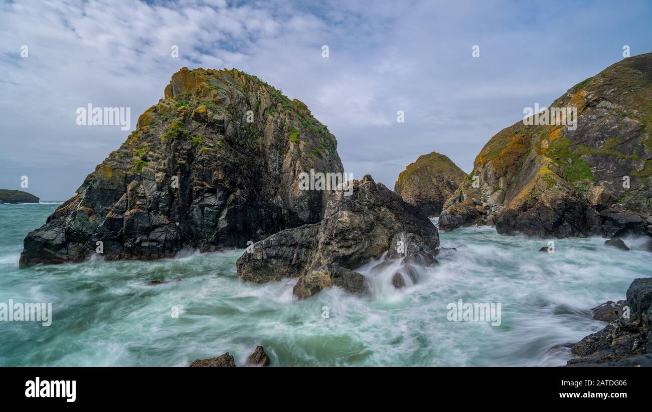 Waves crash on to the rocks and beaches of a cornish coastline, UK ...
