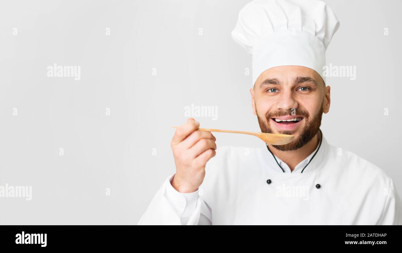 Chef Guy Tasting Dish Holding Spoon Posing On Gray Background Stock ...