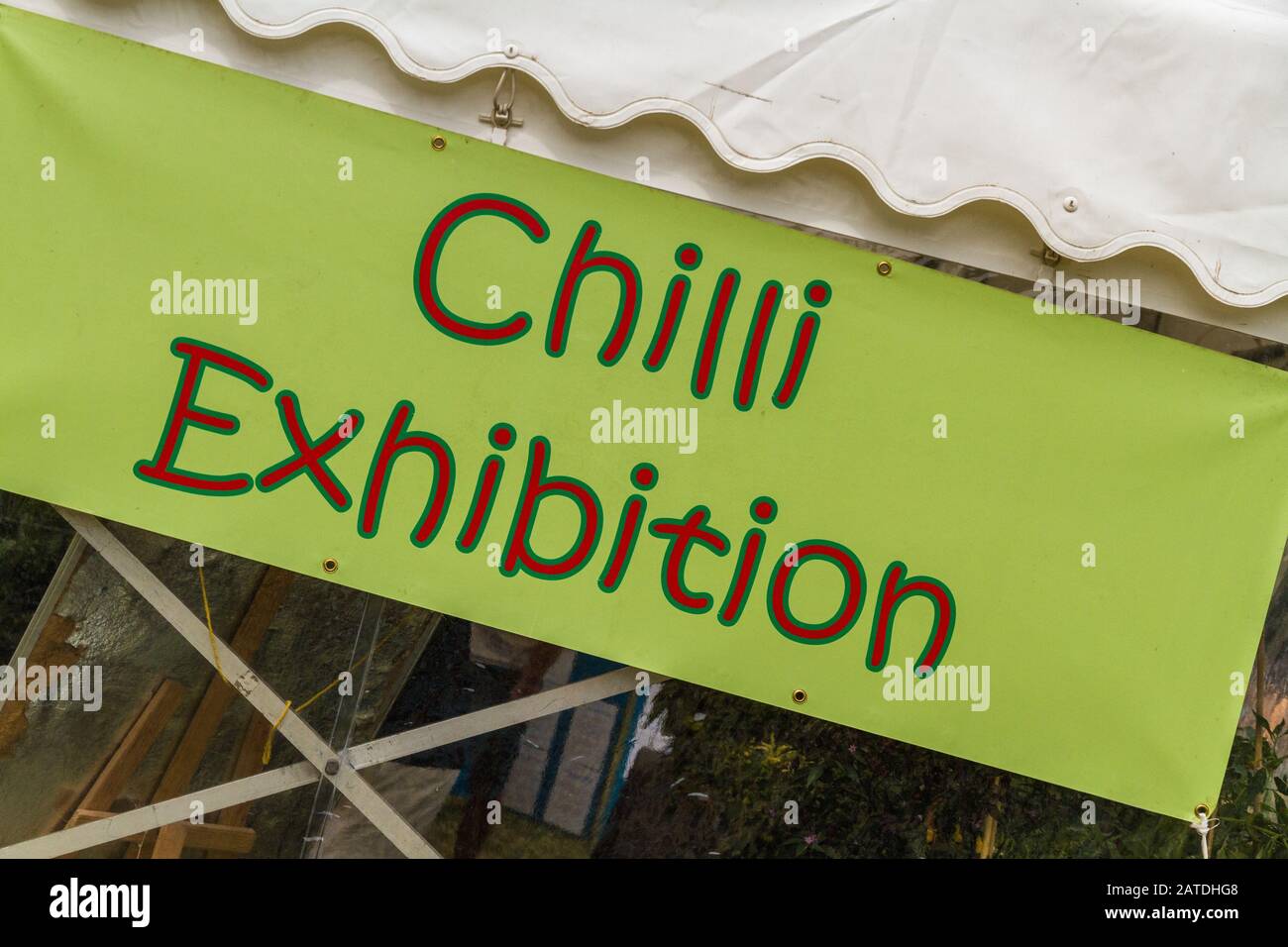 Sign for a chilli exhibition, on green background, slanted view Stock ...