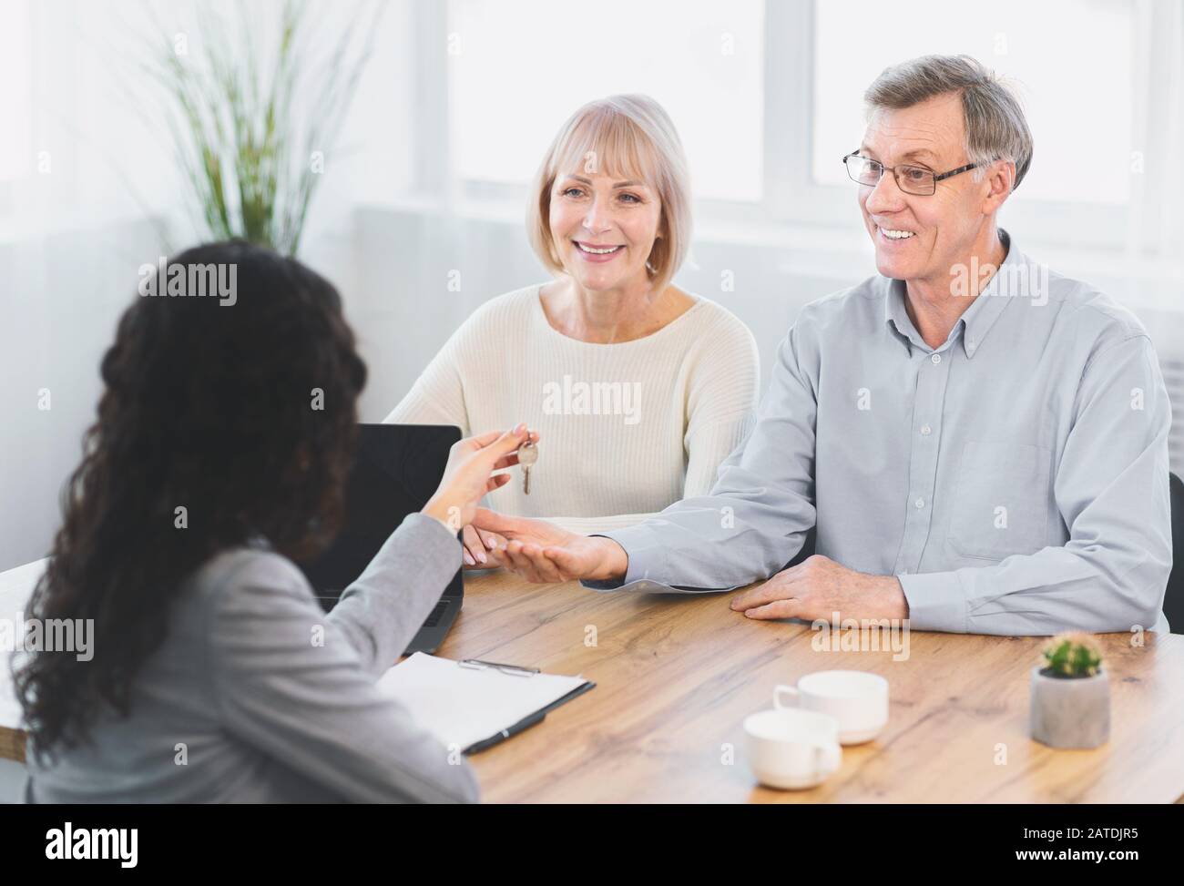 Happy mature couple getting key to their new place Stock Photo - Alamy