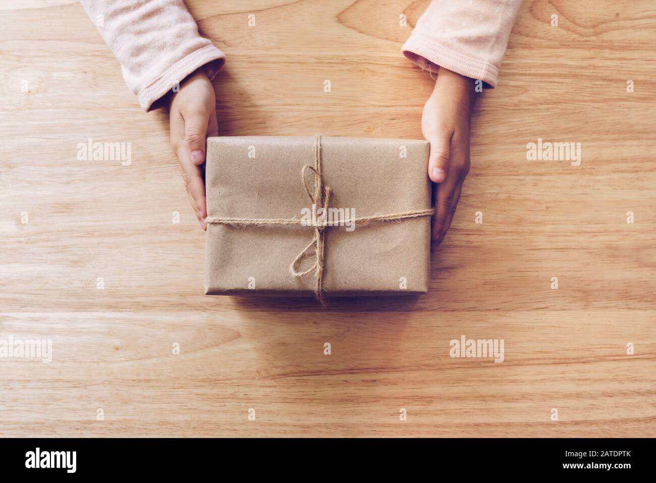 girl hand holding gift box on wood table background Stock Photo - Alamy