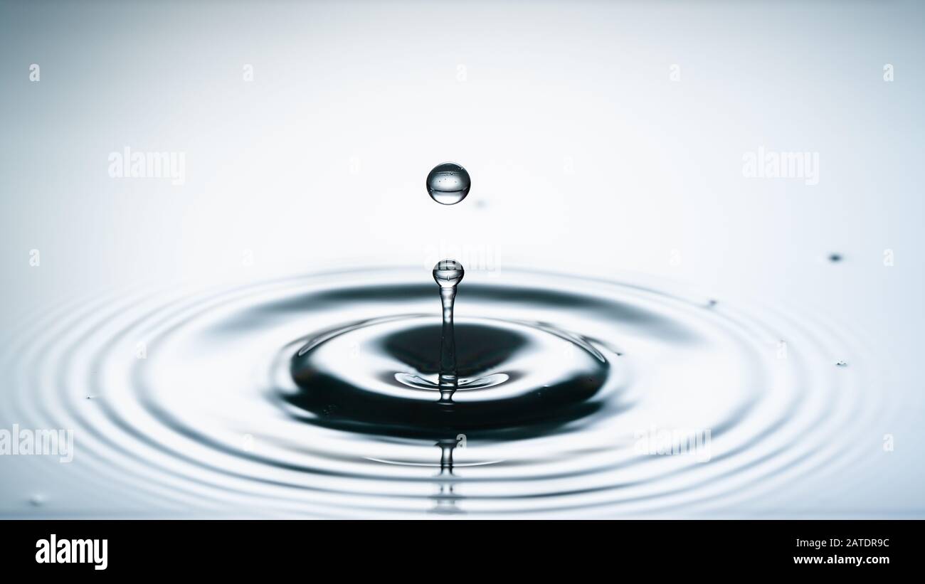 Close-up of a water drop falling on water surface Stock Photo - Alamy