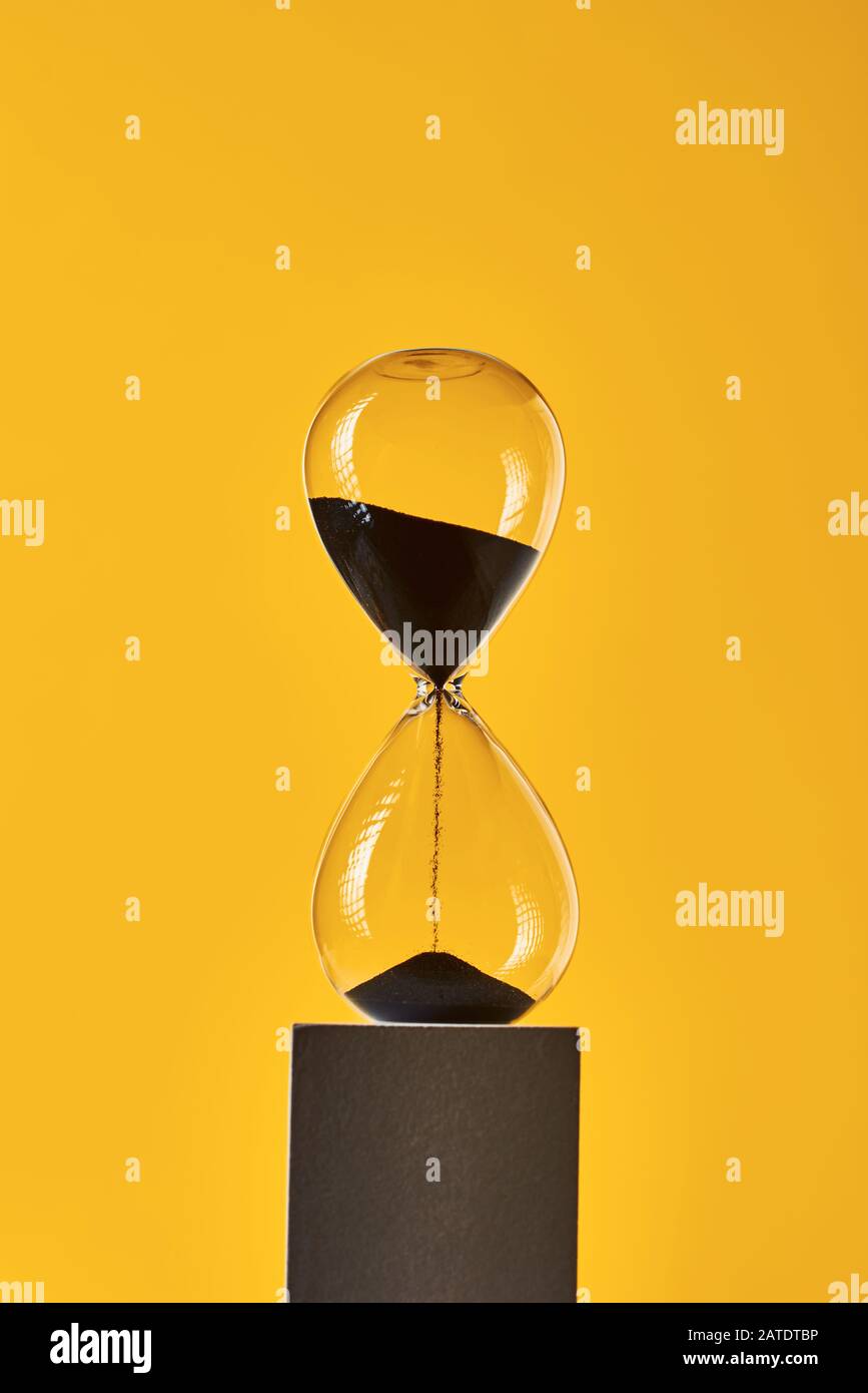 Hourglass on yellow background with copy space. Concept of running out ...