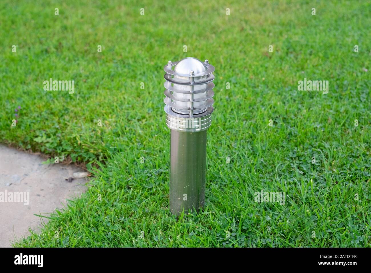 Side view of a small modern metal silver, outdoor garden light on a ...