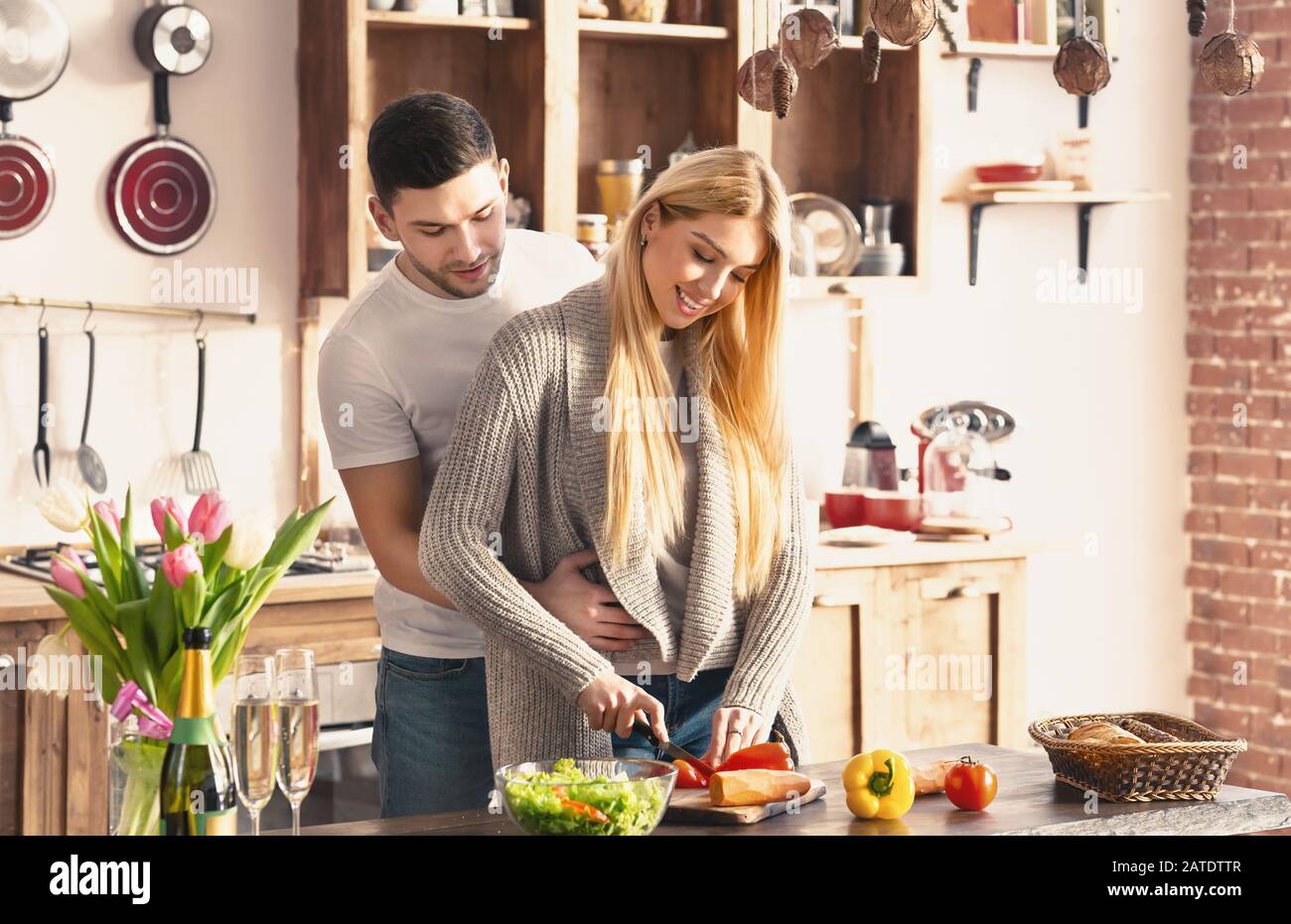 Romantic young couple embracing and cooking together Stock Photo - Alamy