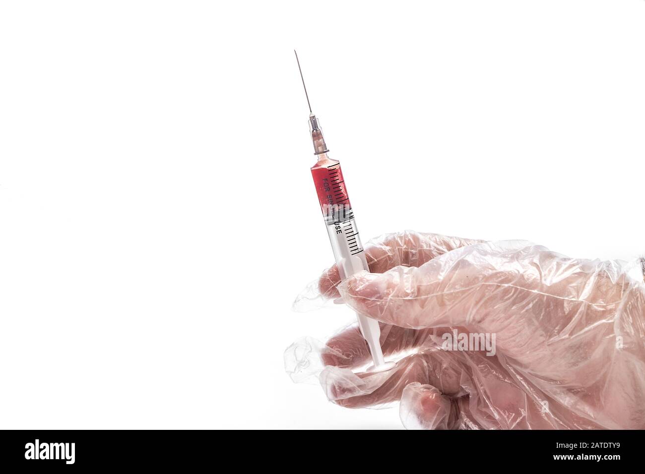 the hand holds a disposable sterile syringe filled with blood on a ...