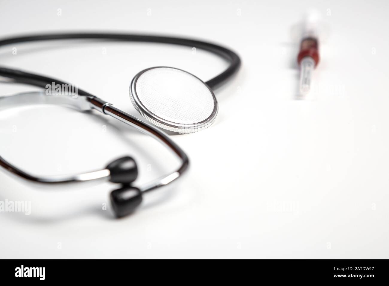 medical stethoscope and syringe with blood samples on a white isolated ...