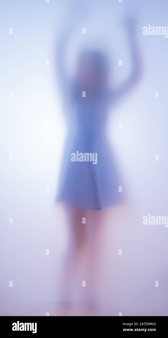 Blurred photo girl wearing dress dancing behind glass Stock Photo - Alamy