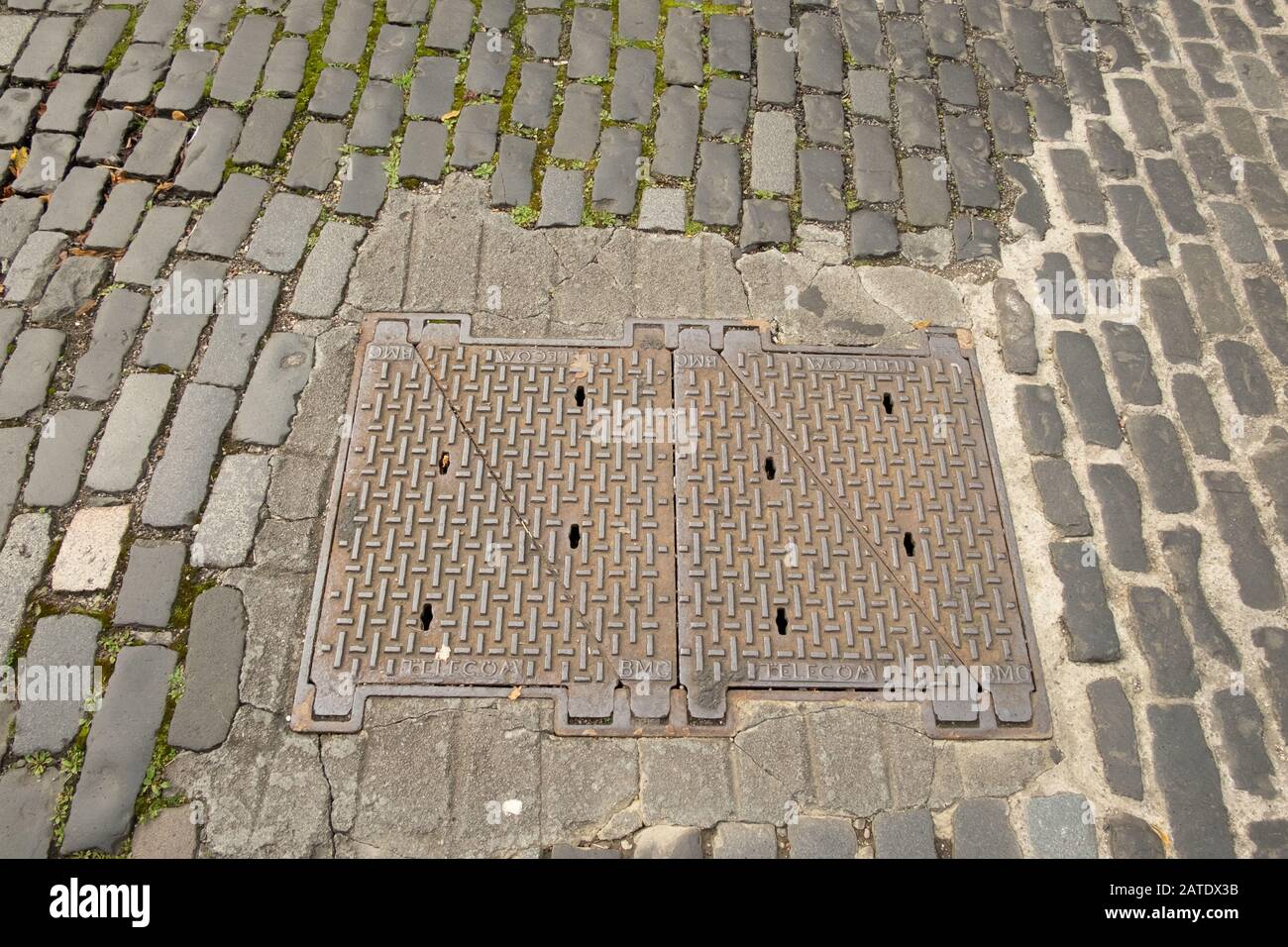 Close-up of metal manhole cover "telecom" in cobbled road, Edinburgh ...