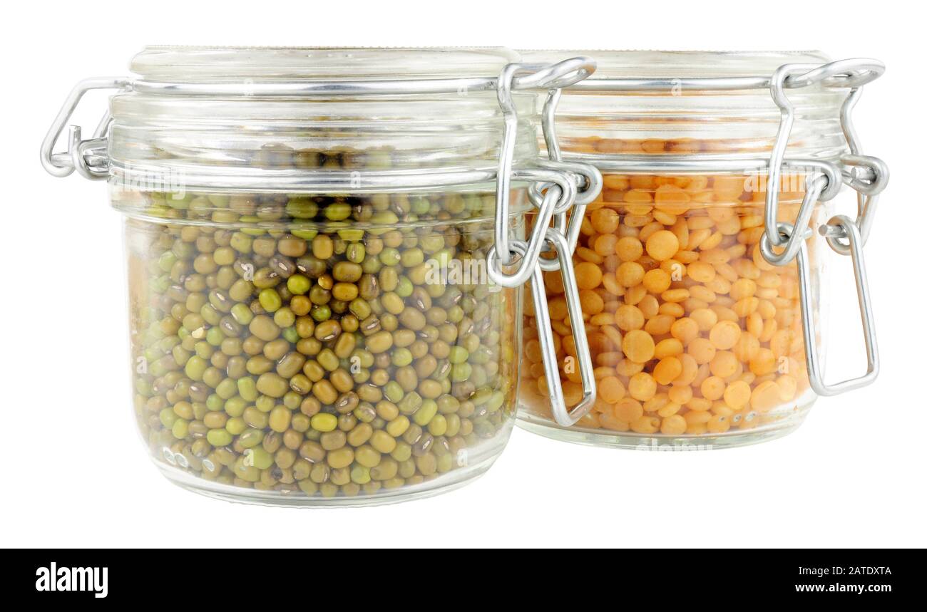 Glass food storage jars filled with green lentils isolated on a white ...